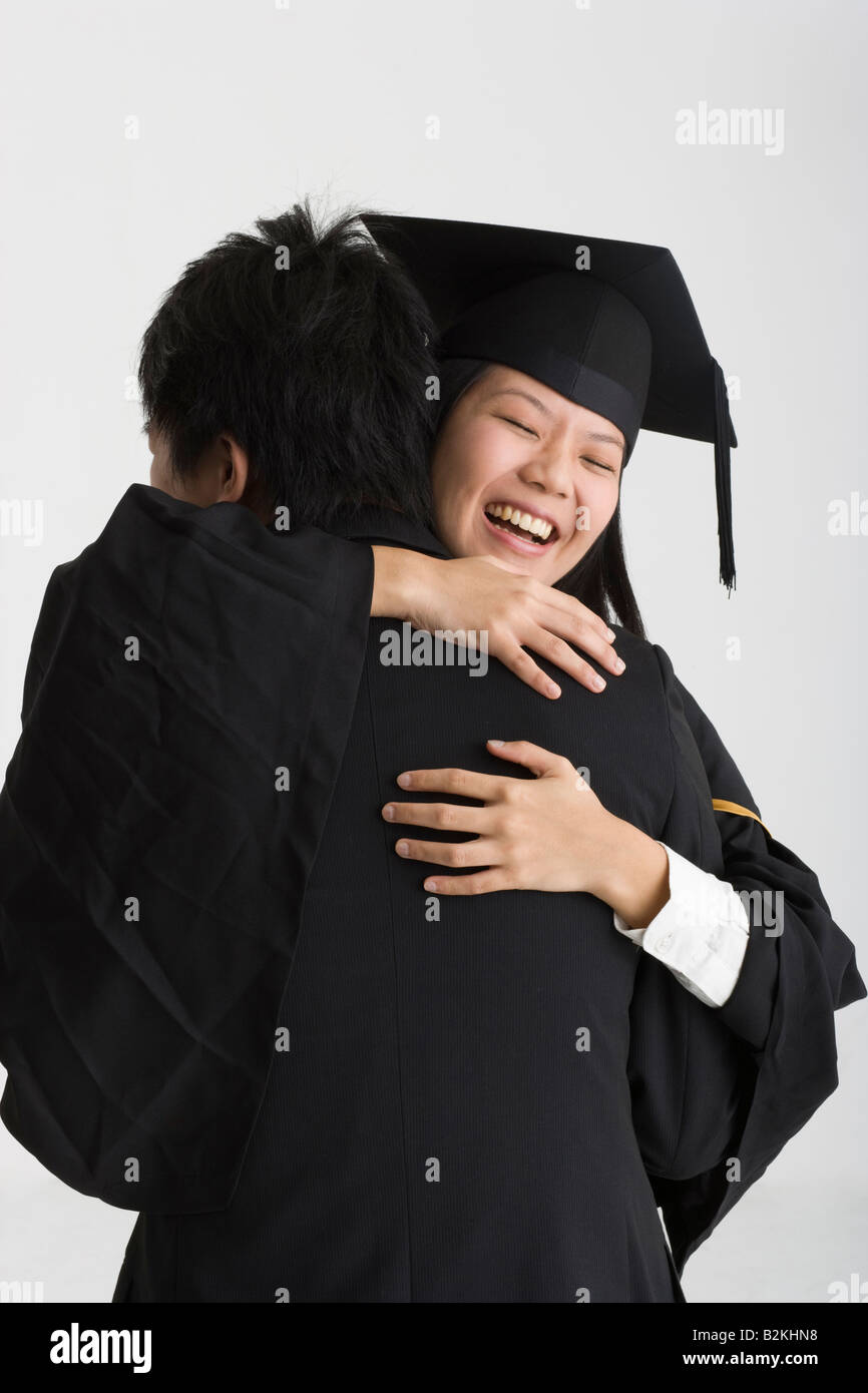 Young female graduate hugging a young man and smiling Stock Photo - Alamy