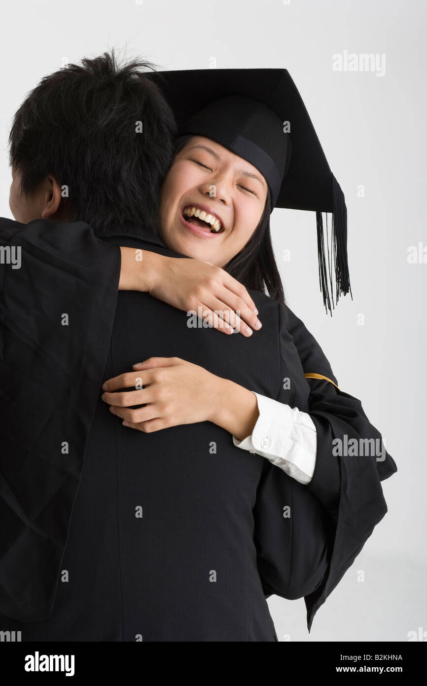 Young female graduate hugging a young man and laughing Stock Photo - Alamy