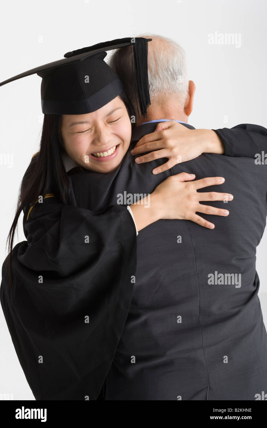 Young female graduate hugging her father and smiling Stock Photo - Alamy