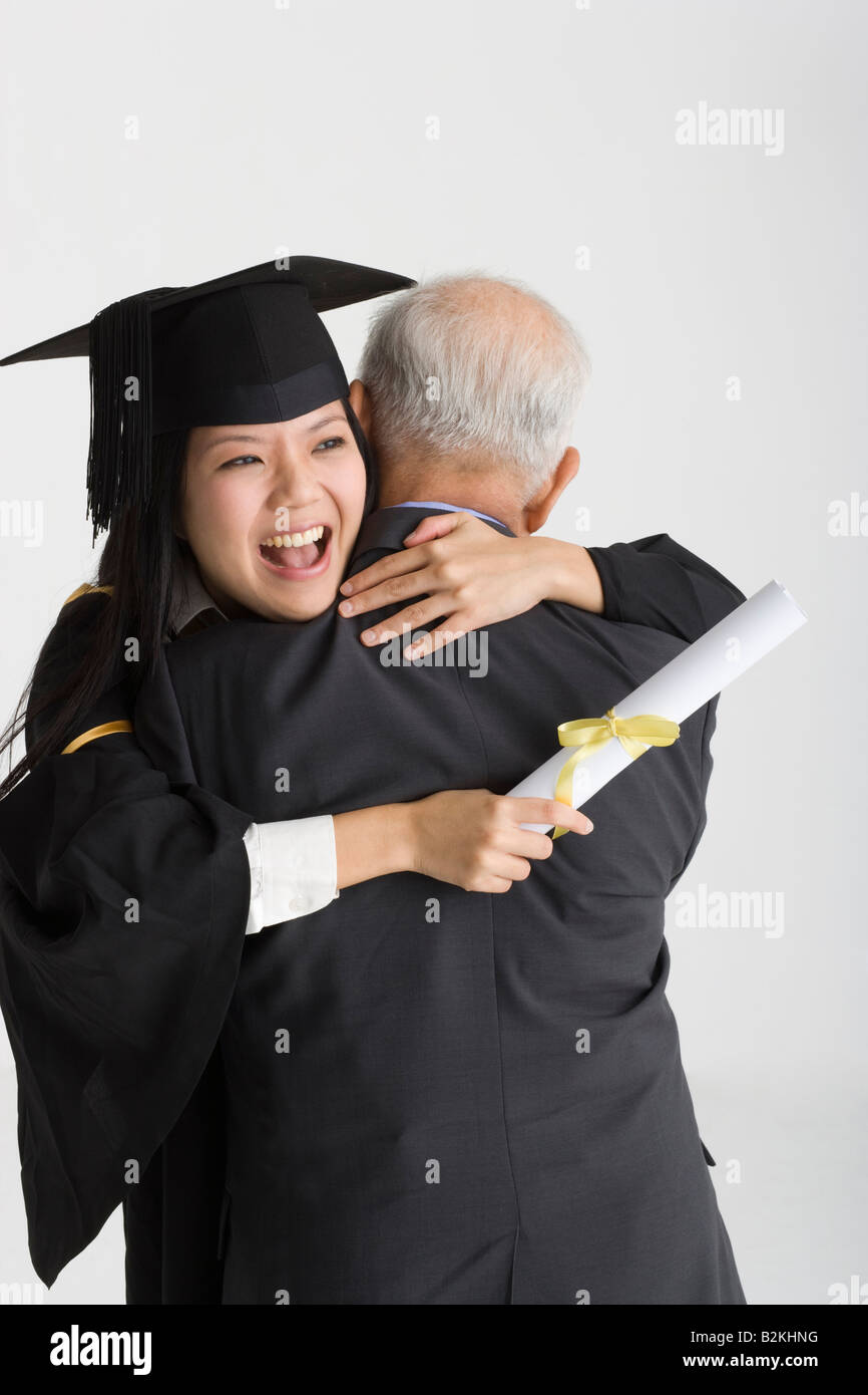Young female graduate hugging her father and laughing Stock Photo - Alamy