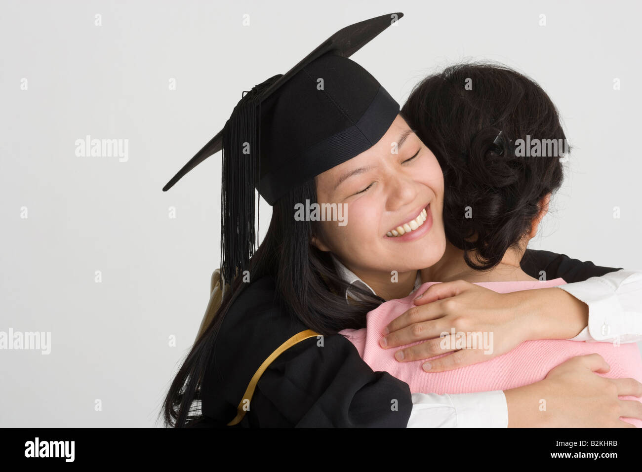 Young female graduate hugging her mother and smiling Stock Photo - Alamy