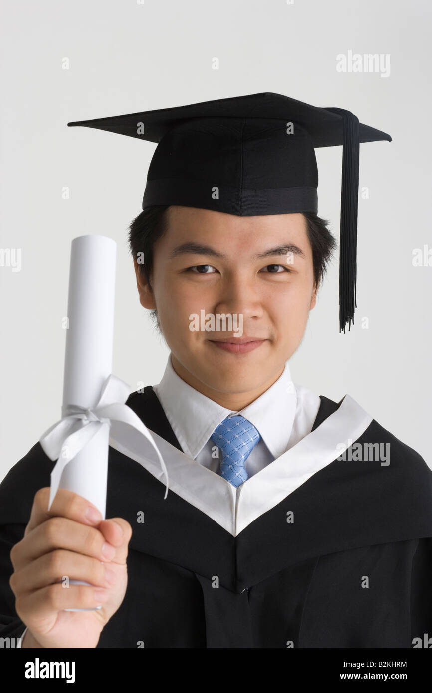 Portrait of a young male graduate holding a diploma and smiling Stock ...