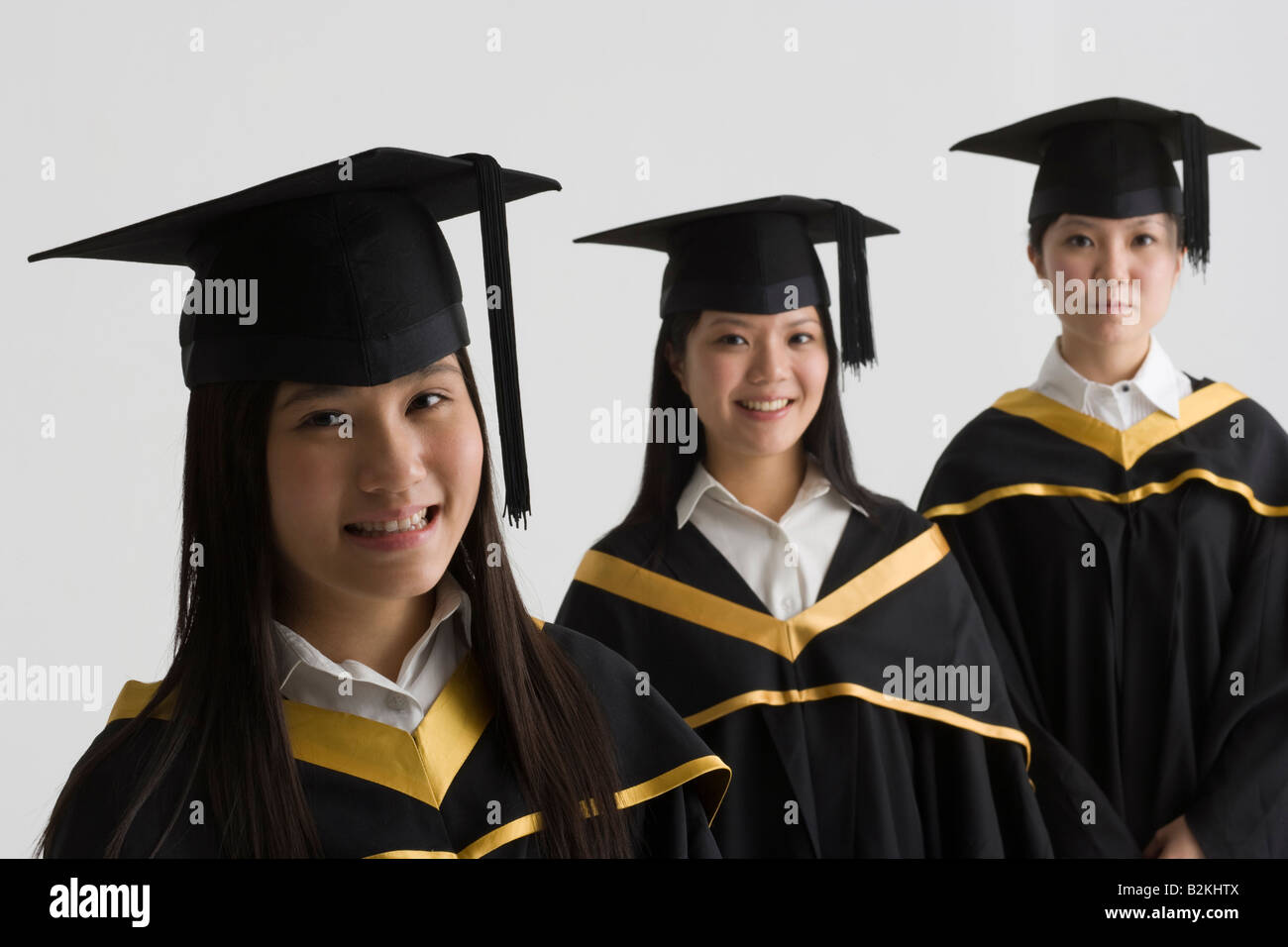 Portrait of three young female graduates in a row Stock Photo - Alamy