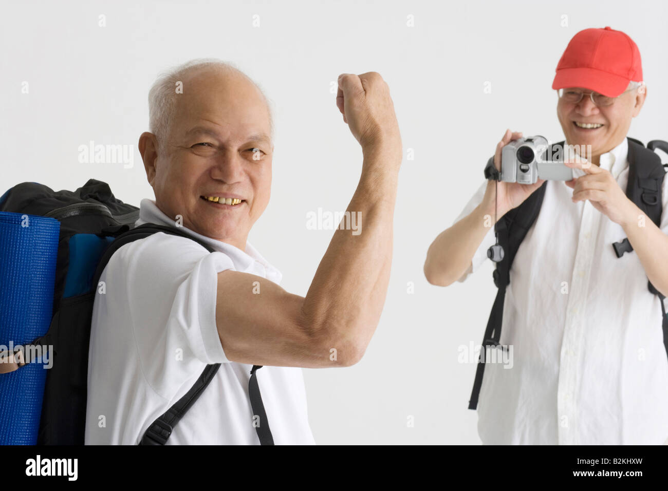 Senior man filming his friend flexing muscles Stock Photo - Alamy