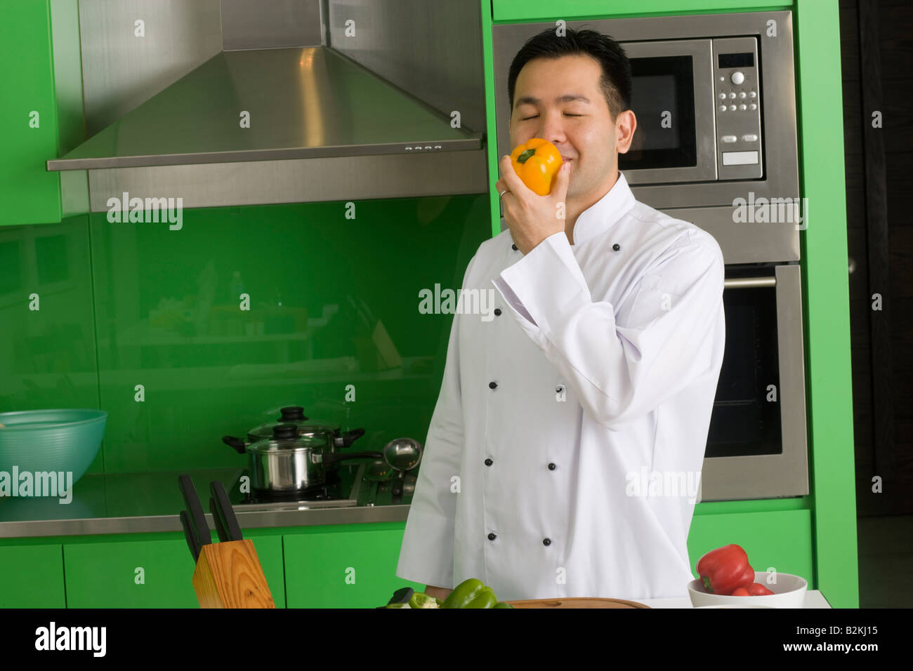 Close-up of a male chef smelling a yellow bell pepper Stock Photo - Alamy
