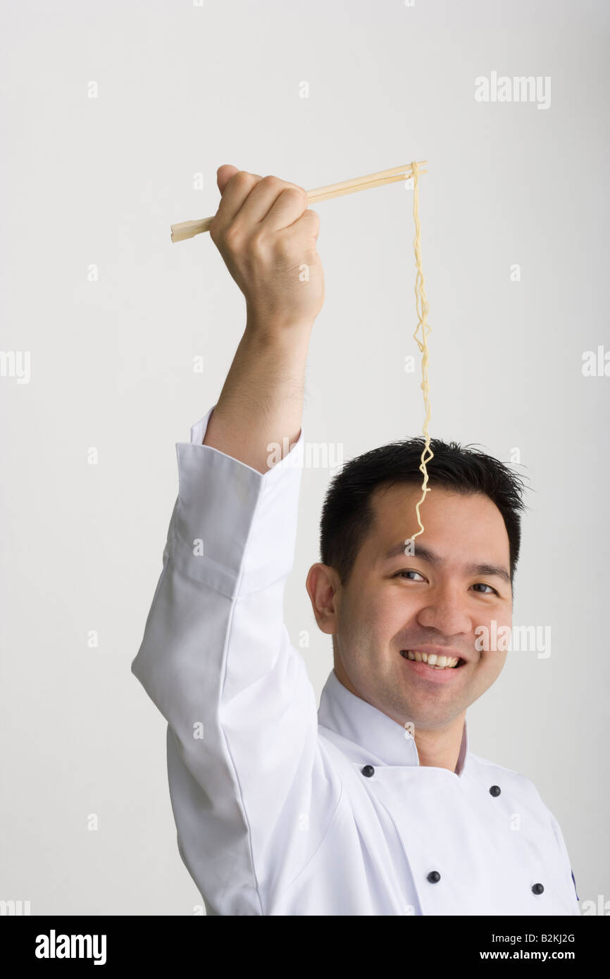 Portrait of a male chef tasting noodles and smiling Stock Photo - Alamy