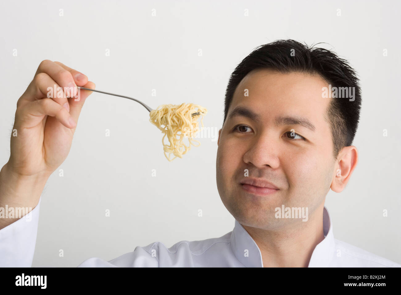 Close-up of a male chef tasting noodles Stock Photo - Alamy