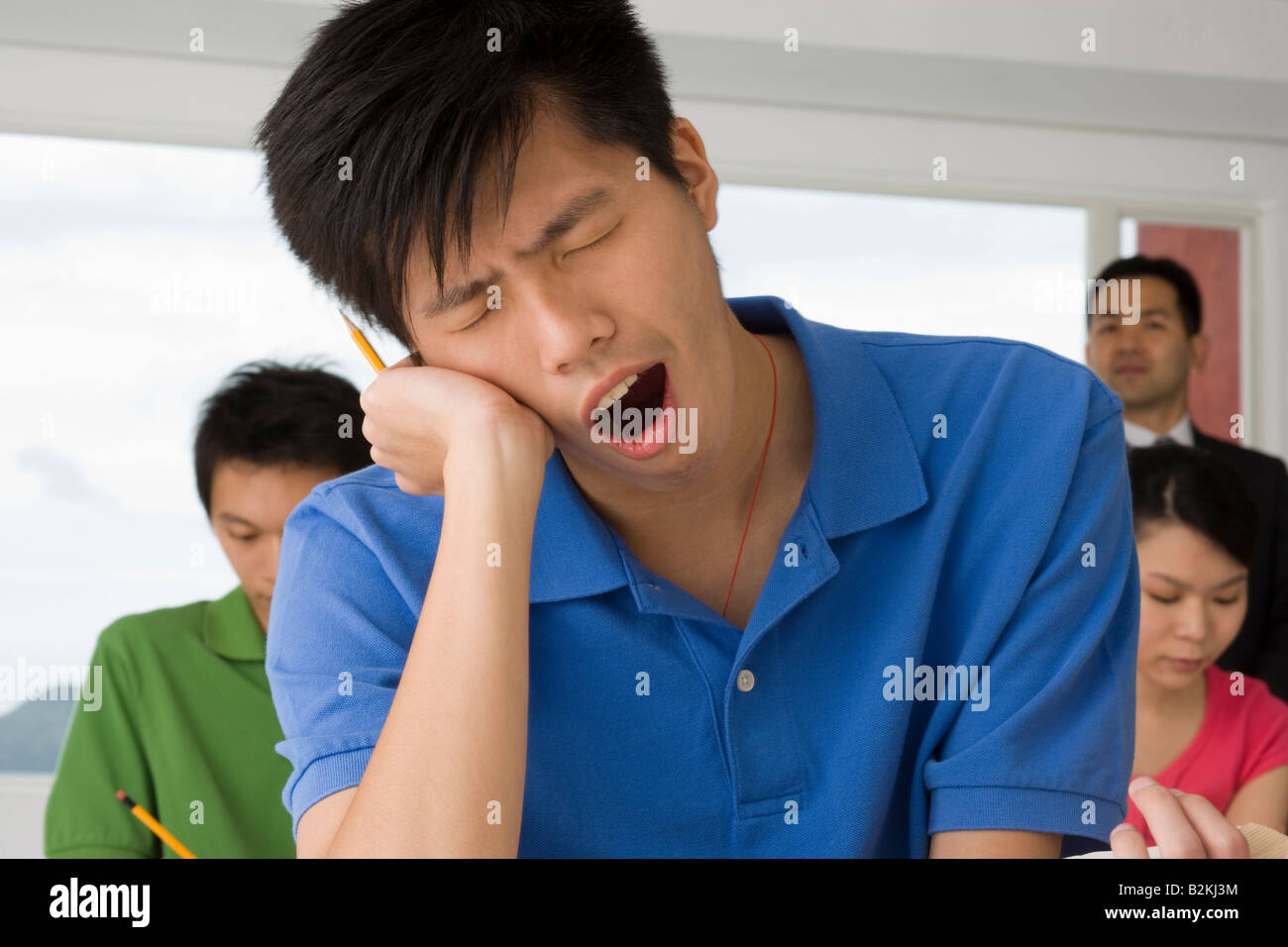 Close-up of a student yawning in a classroom Stock Photo - Alamy