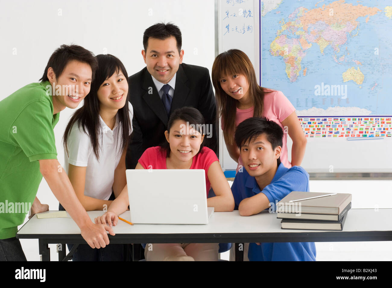 Portrait of a professor smiling with his students in the classroom ...