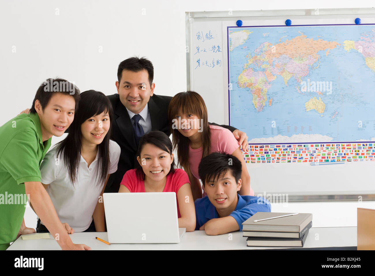 Portrait of a professor smiling with his students in the classroom ...