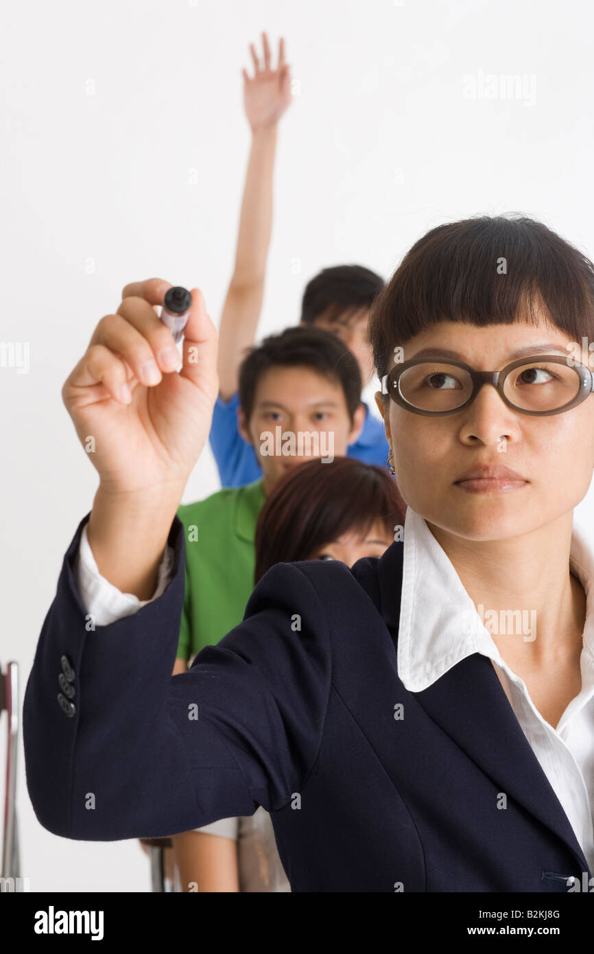 Female professor holding a felt tip pen in a classroom Stock Photo - Alamy