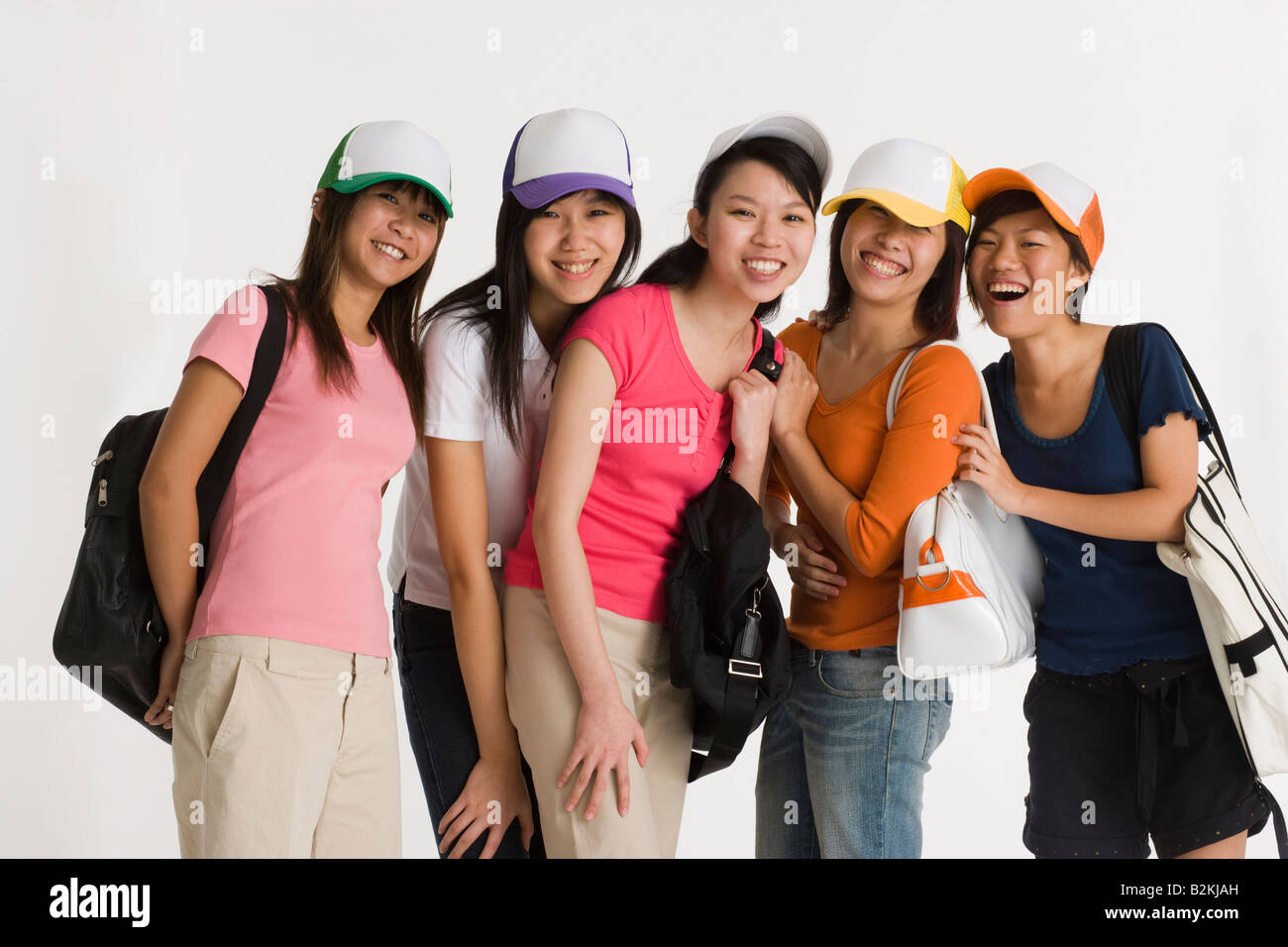 Portrait of five young women standing and smiling together Stock Photo ...