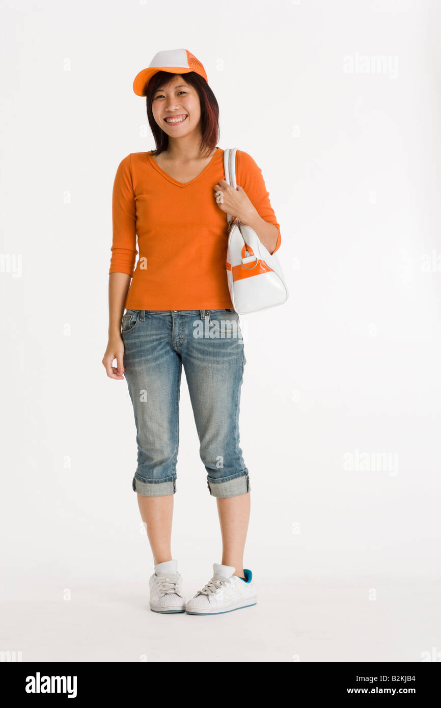 Portrait of a young woman standing and smiling Stock Photo - Alamy