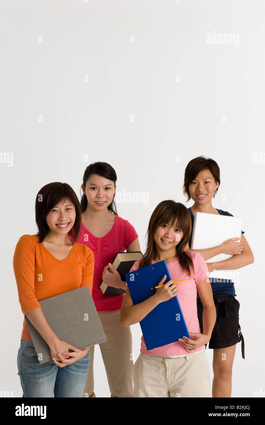 Portrait of four female university students standing and smiling ...