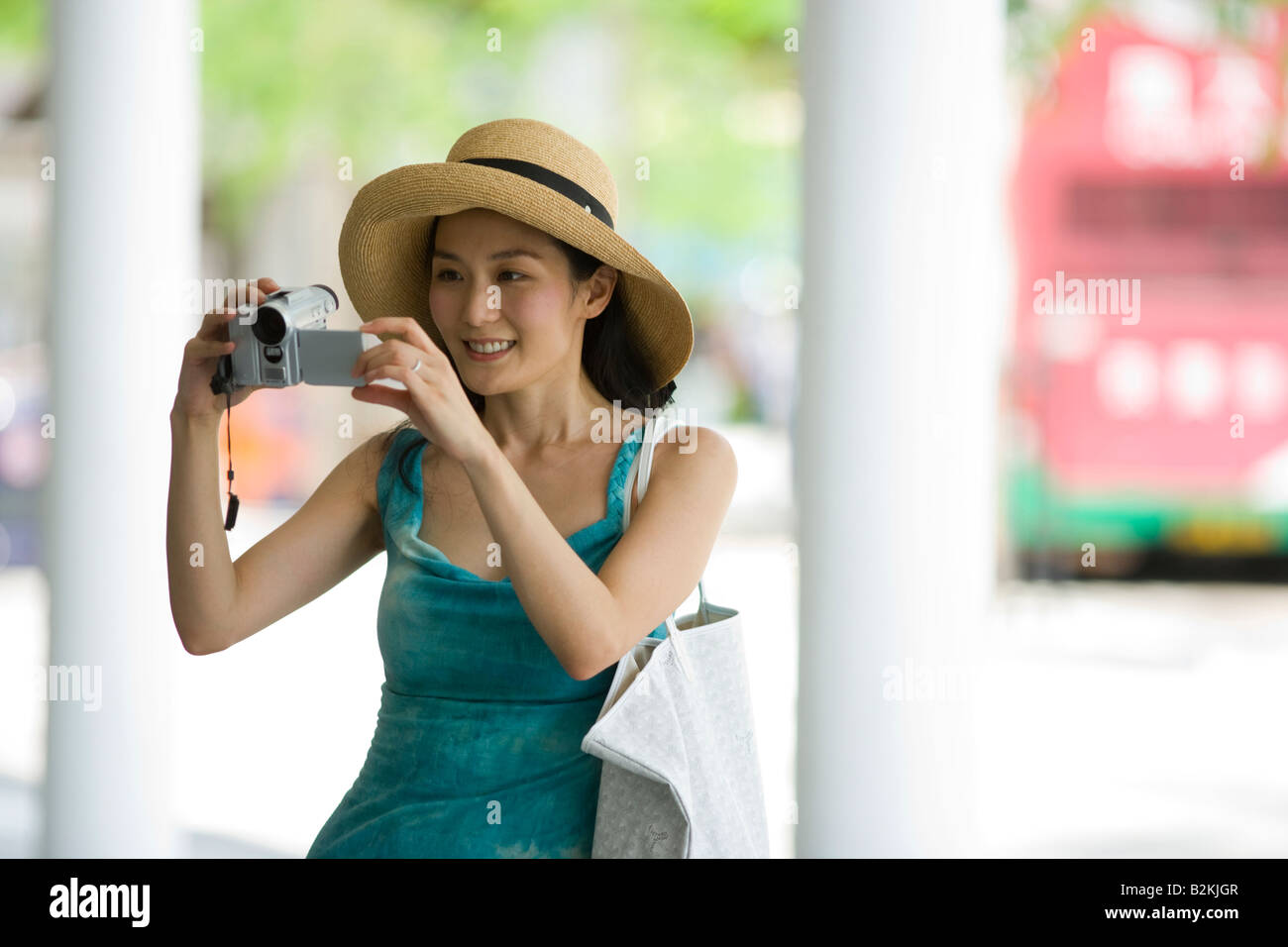 Young woman filming with a home video camera and smiling Stock Photo ...
