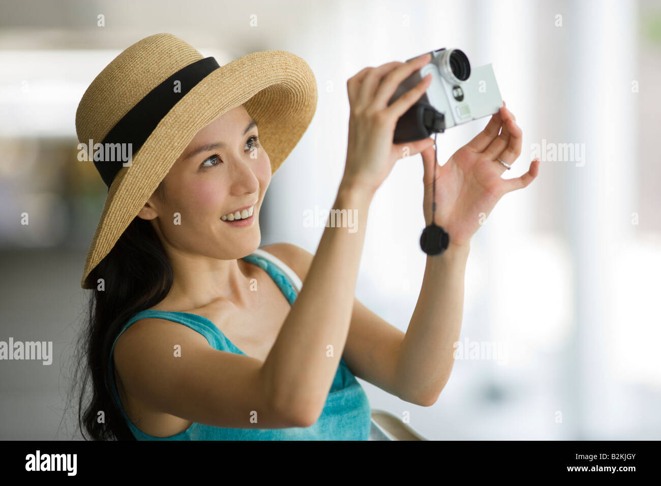Side profile of a young woman filming with a home video camera and ...