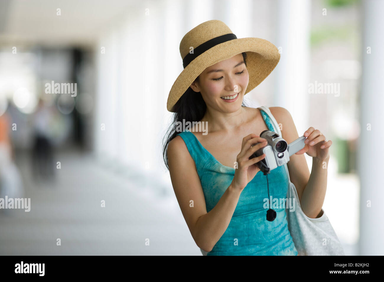 Young woman filming with a home video camera and smiling Stock Photo ...