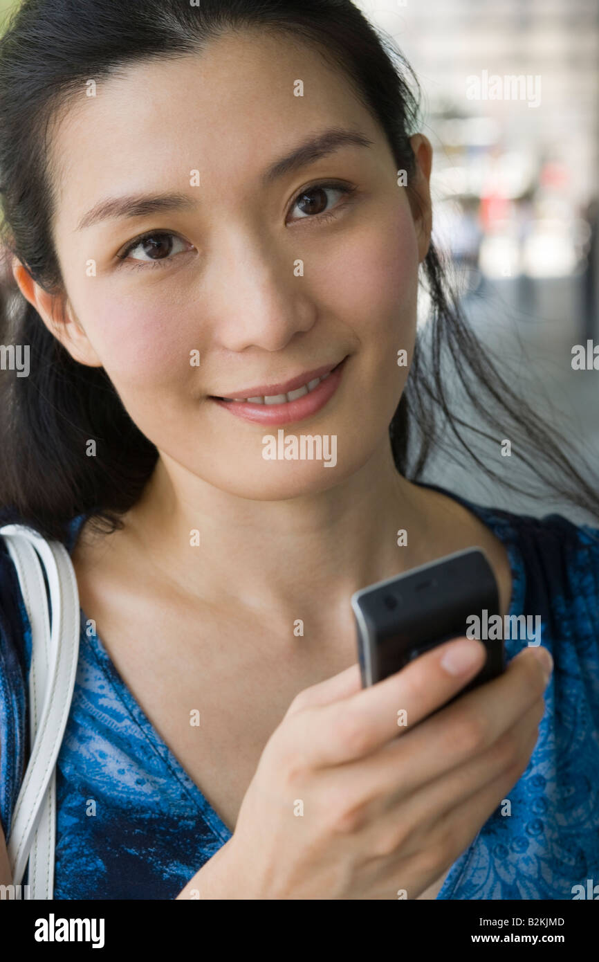 Portrait of a young woman text messaging and smiling Stock Photo - Alamy