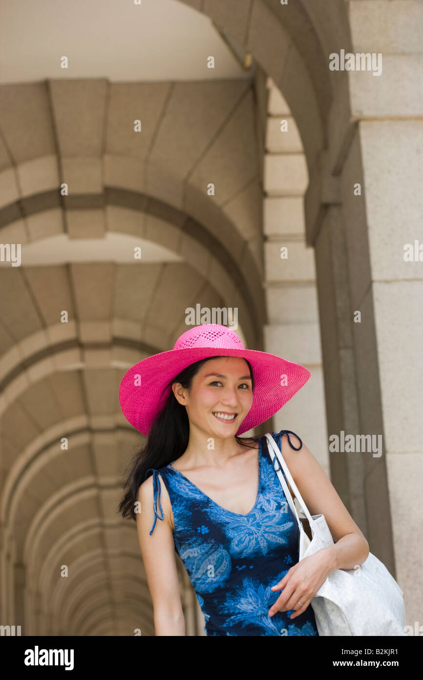 Portrait of a young woman carrying a hand bag and smiling Stock Photo ...