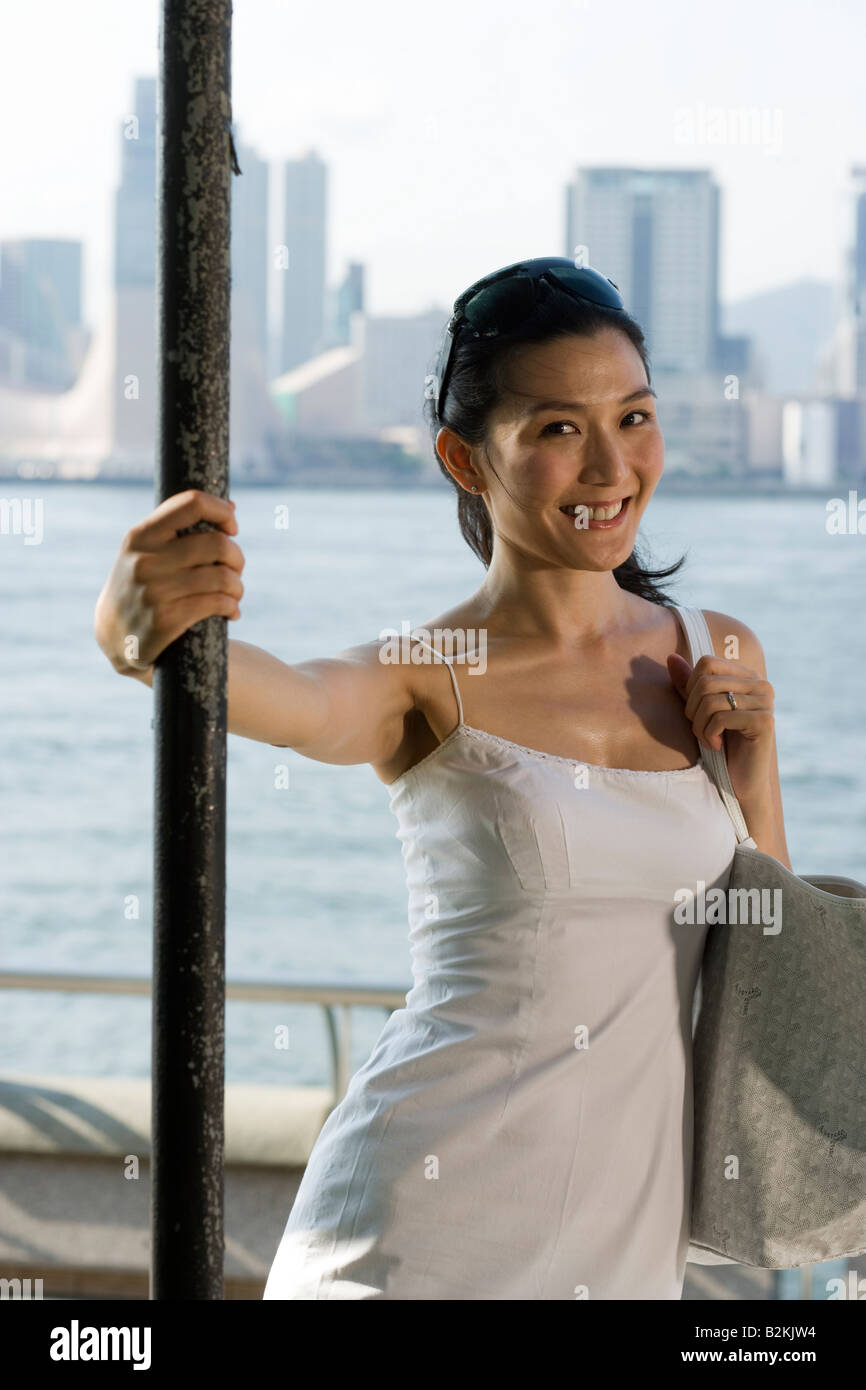 Portrait of a young woman holding a pole and smiling Stock Photo - Alamy