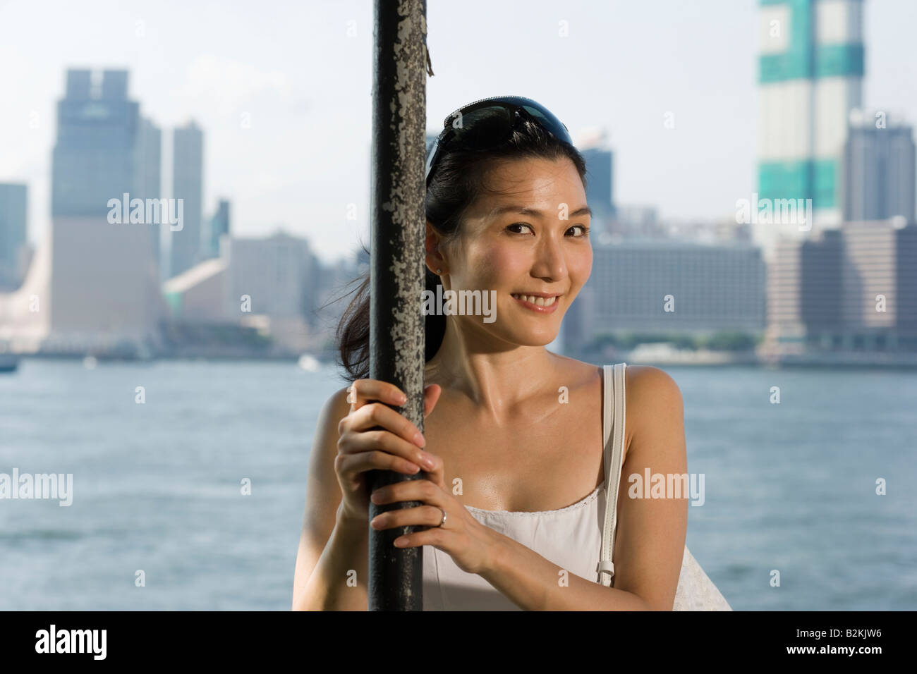 Portrait of a young woman holding a pole and smiling Stock Photo - Alamy