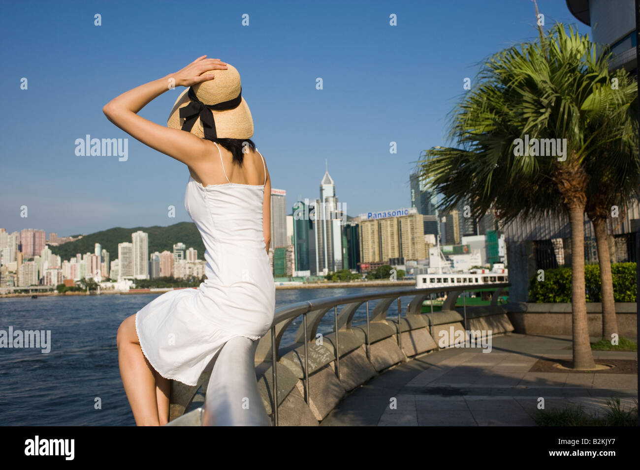 Side profile of a woman sitting on a railing hi-res stock photography ...