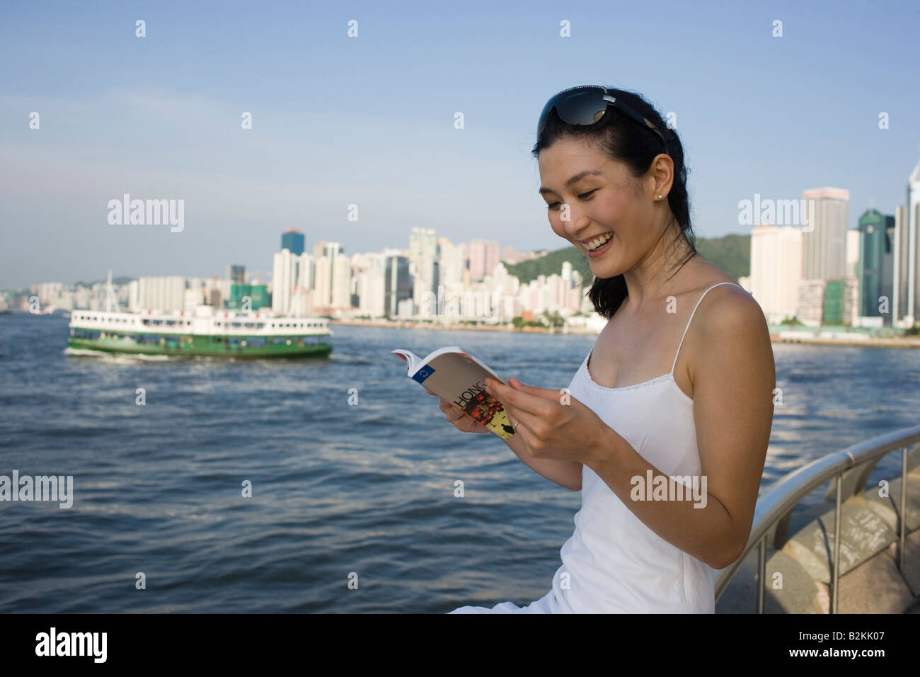 Young woman reading a book at the seaside Stock Photo - Alamy