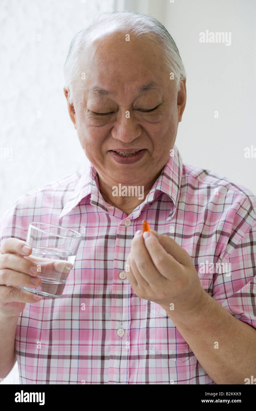 Close-up of a senior man taking a capsule Stock Photo - Alamy