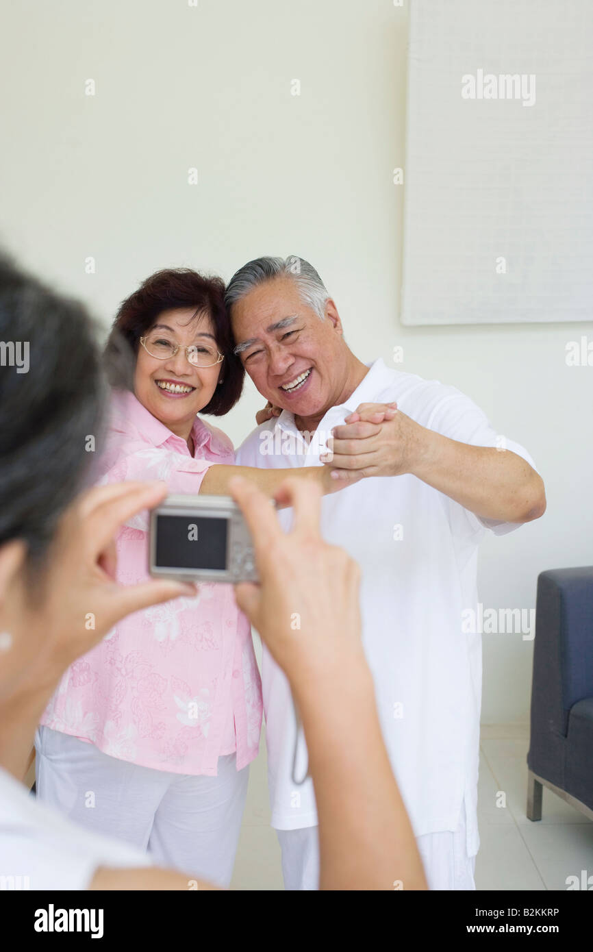 Senior woman photographing a senior couple with a digital camera Stock ...