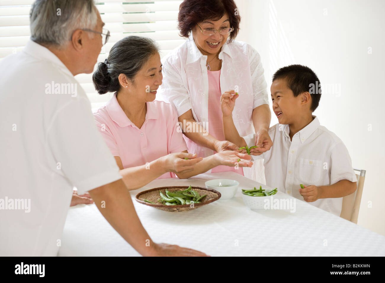 Family podding green peas Stock Photo - Alamy