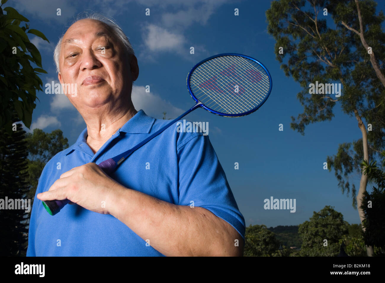 Portrait of a senior man holding a badminton racket Stock Photo - Alamy