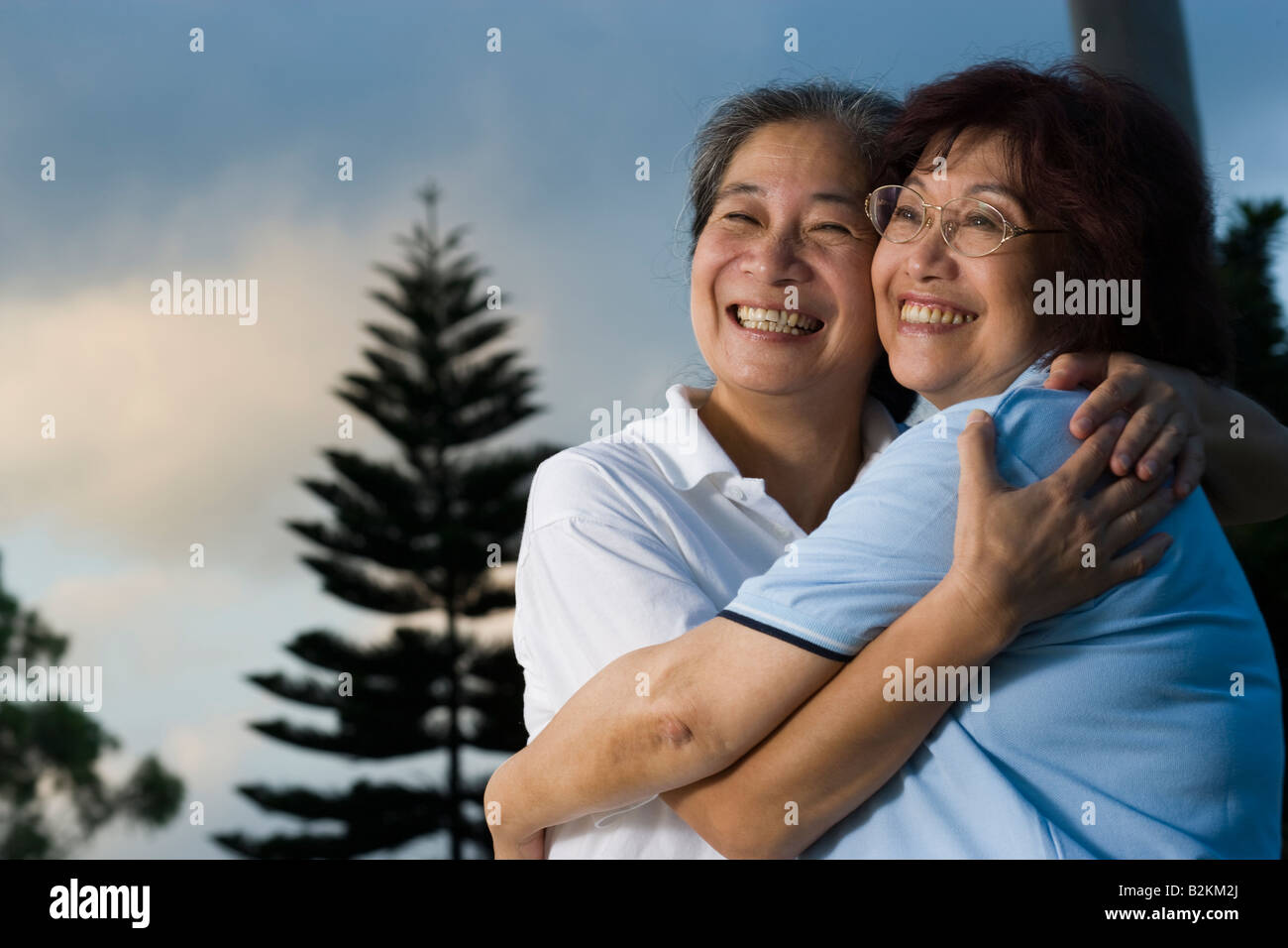 Two senior women hugging each other and smiling Stock Photo - Alamy
