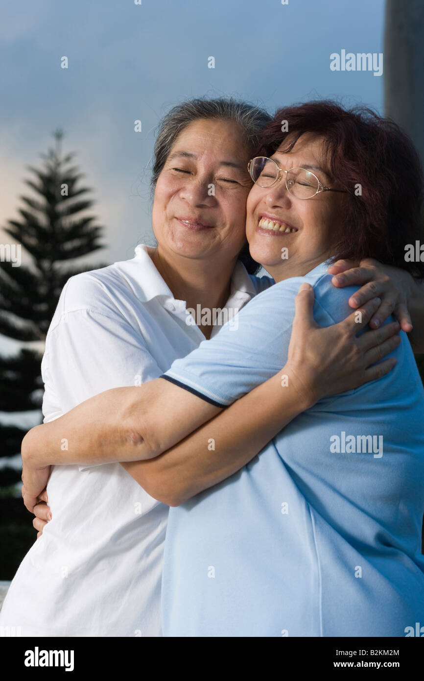 Two senior women hugging each other and smiling Stock Photo - Alamy
