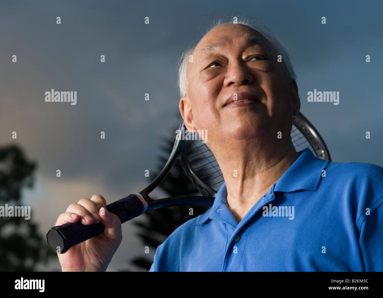 Low angle view of a senior man holding a tennis racket Stock Photo - Alamy