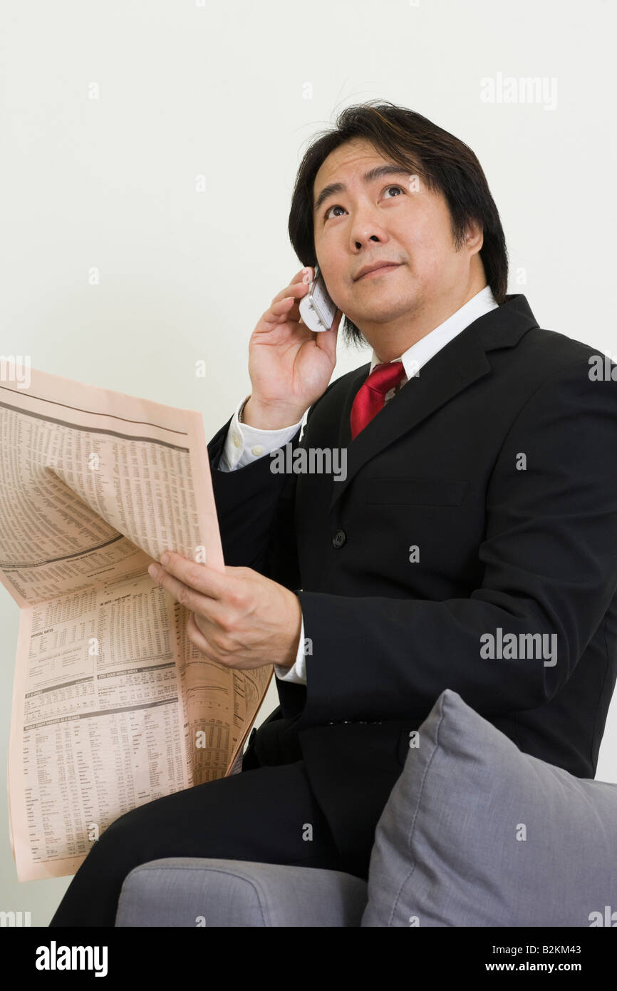 Side profile of a businessman talking on a mobile phone and holding a ...
