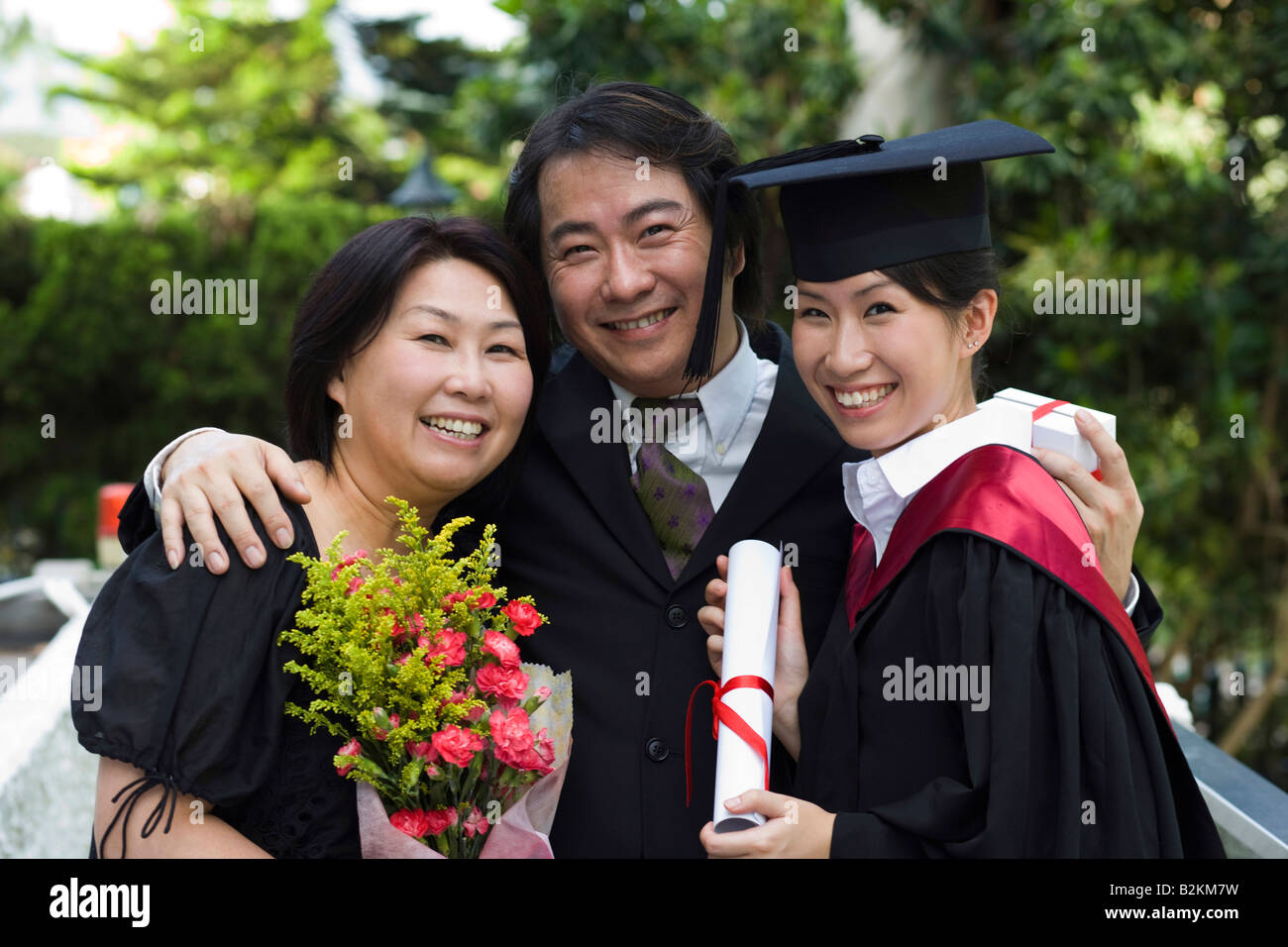 Portrait of a female graduate with her parents and smiling Stock Photo ...