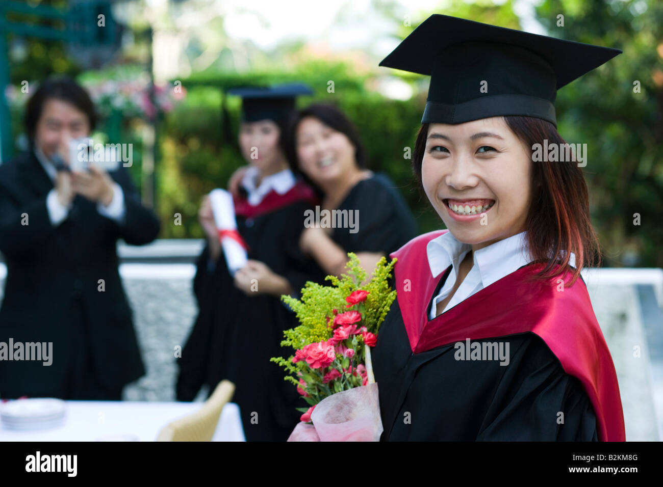 Graduate holding bouquet flowers graduation hi-res stock photography ...
