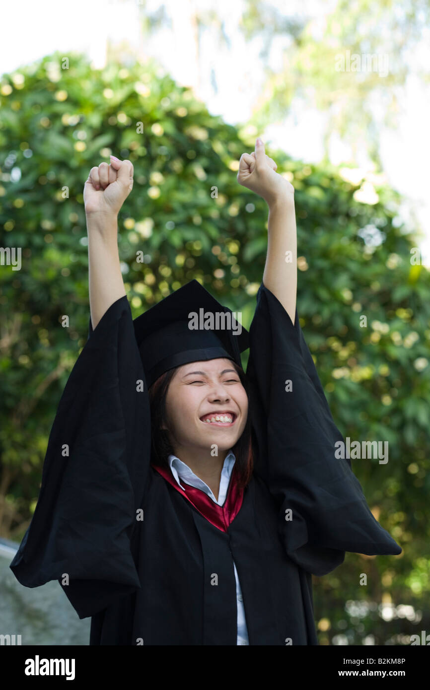 Mid adult female graduate smiling with her arms raised Stock Photo - Alamy
