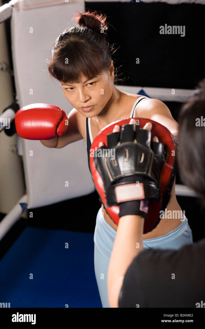Young woman practicing boxing with her instructor Stock Photo - Alamy
