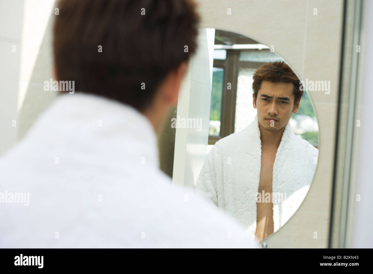Young man standing in front of a mirror Stock Photo - Alamy