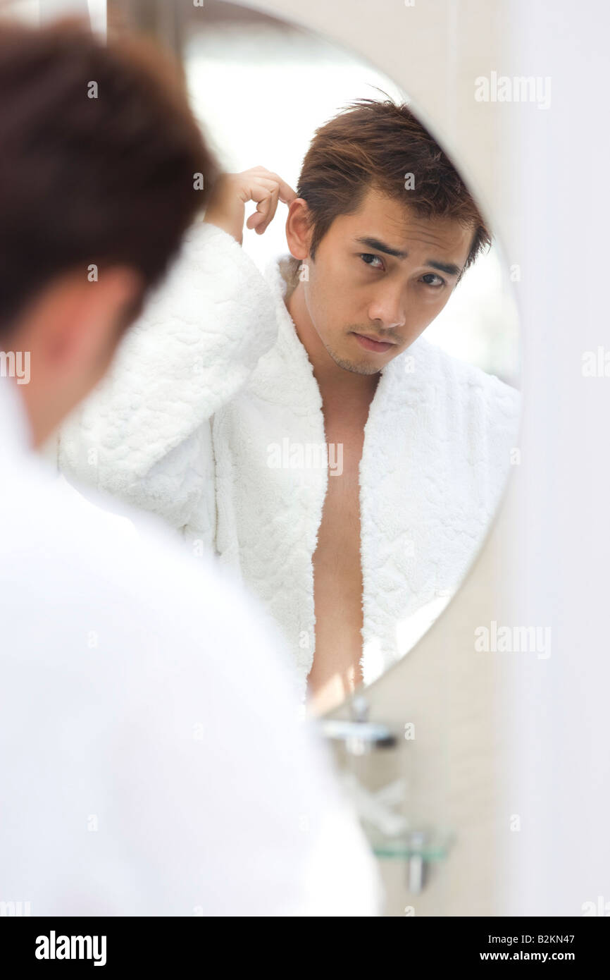Young man standing in front of a mirror Stock Photo - Alamy