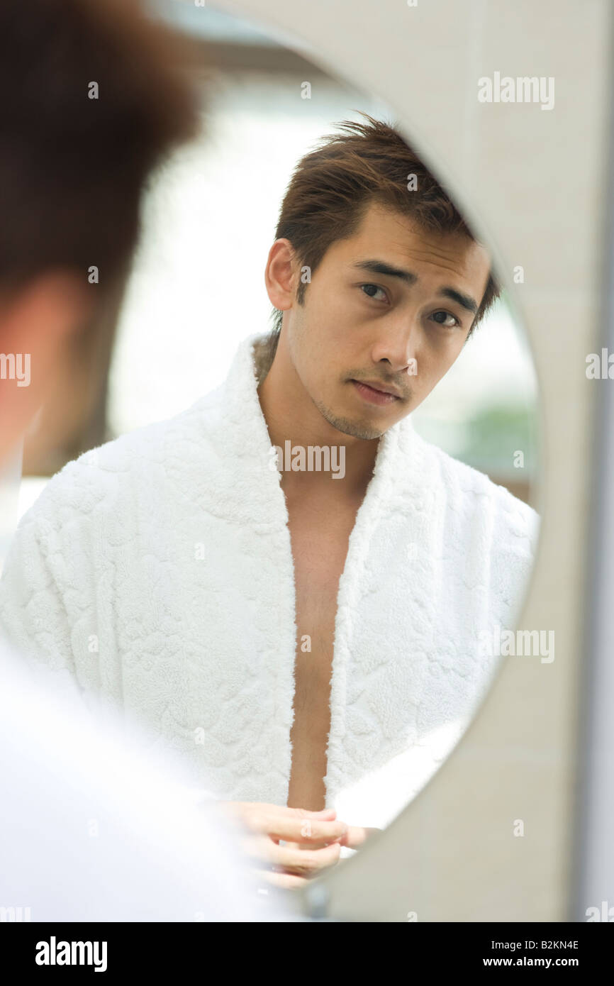 Young man standing in front of a mirror Stock Photo - Alamy