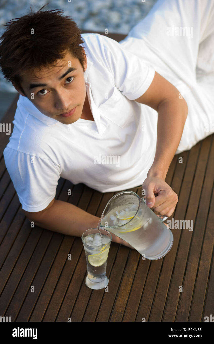 Portrait of a young man pouring lemonade into a glass Stock Photo - Alamy