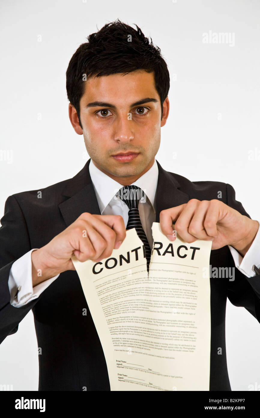 A man in a suit tearing up a contract Stock Photo - Alamy