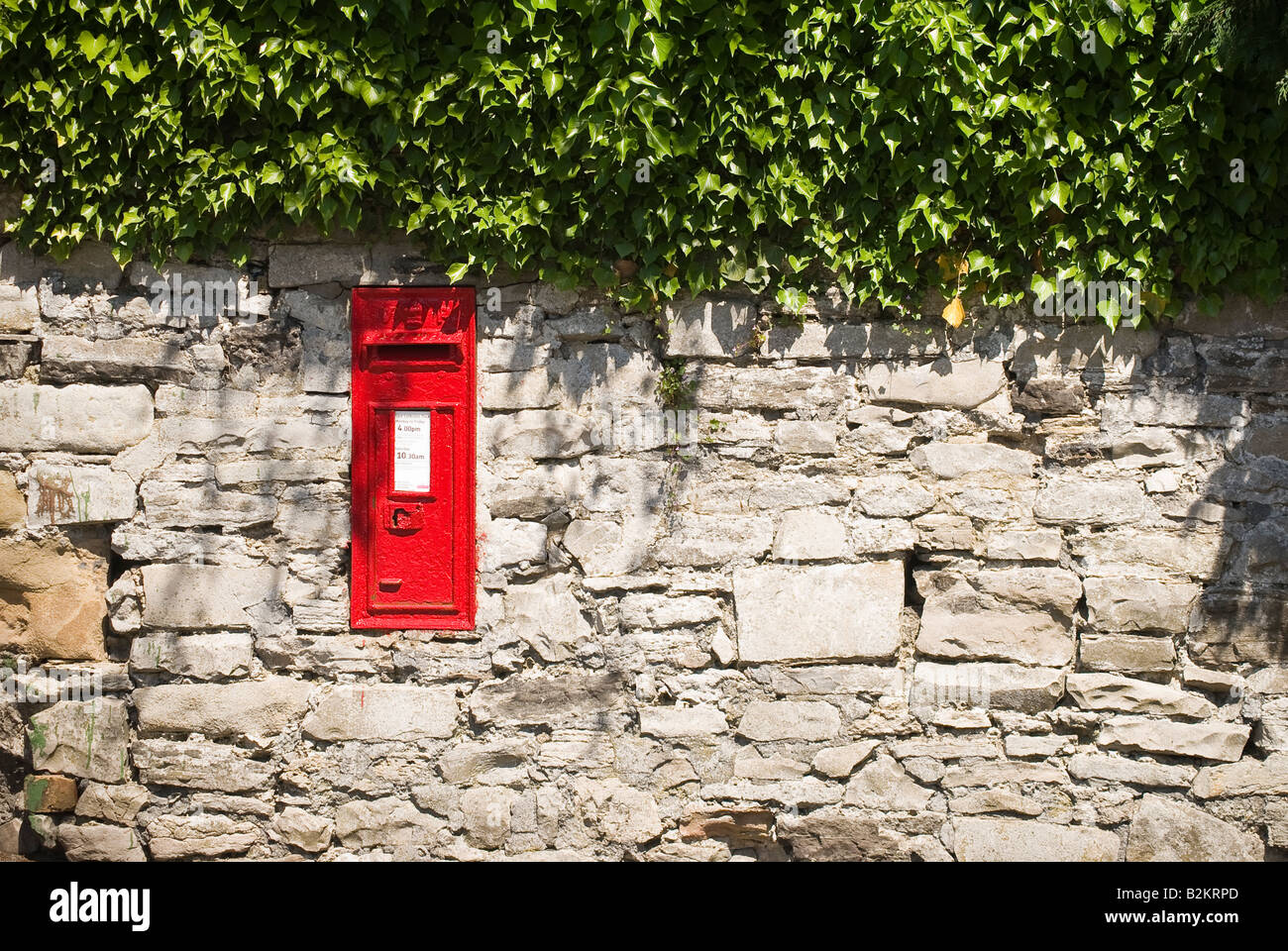 Red letterbox in a stone wall Stock Photo - Alamy