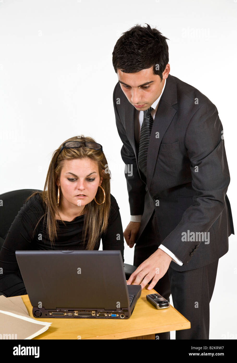 A man and woman look at a laptop in an office Stock Photo - Alamy