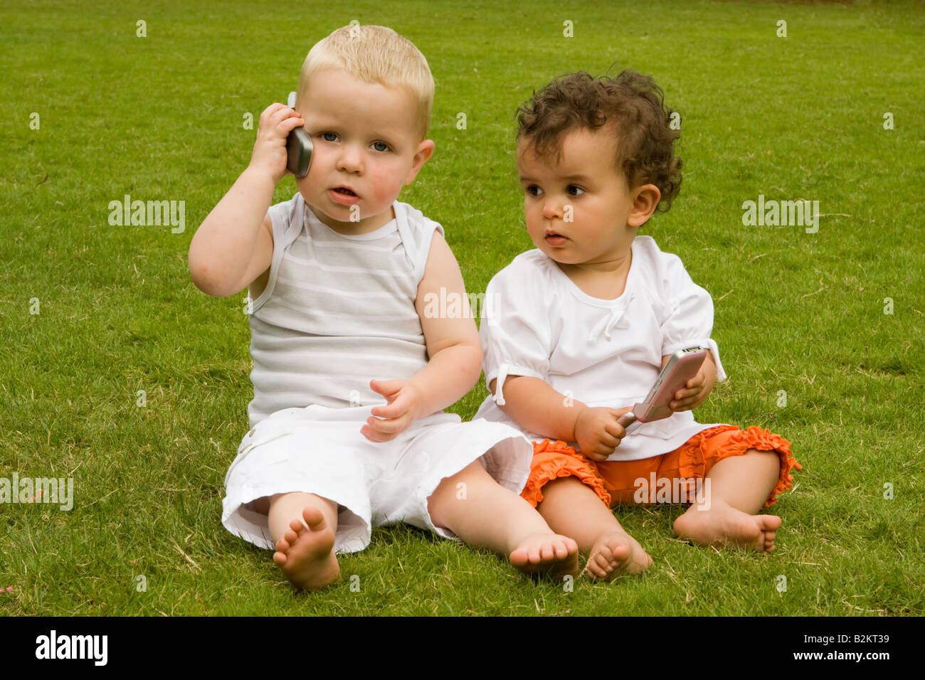 Two children playing with the mobile phones of their parents Stock ...