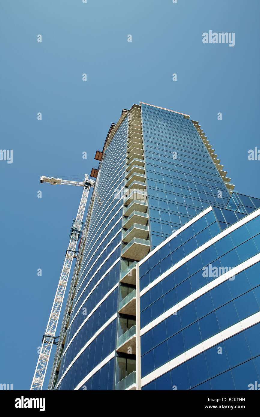The glass windows of a new condominium high rise reflecting a bright ...