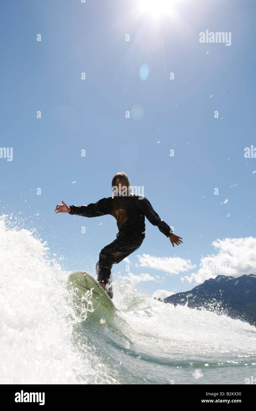 wave surfing behind a boat on green lake in whistler British Columbia ...