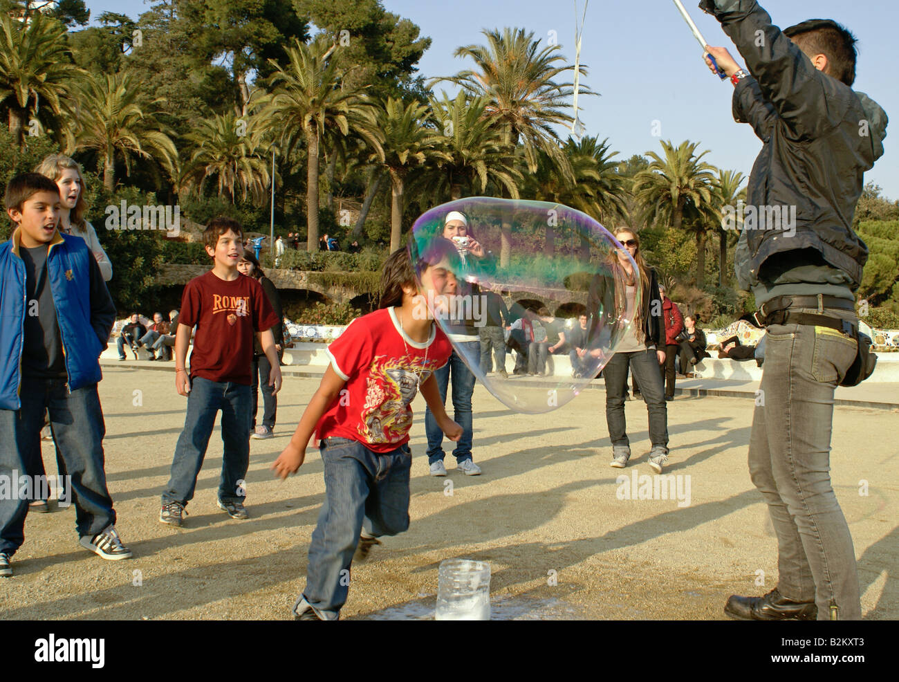 Children playing with soap bubbles from a street performer, in Park ...